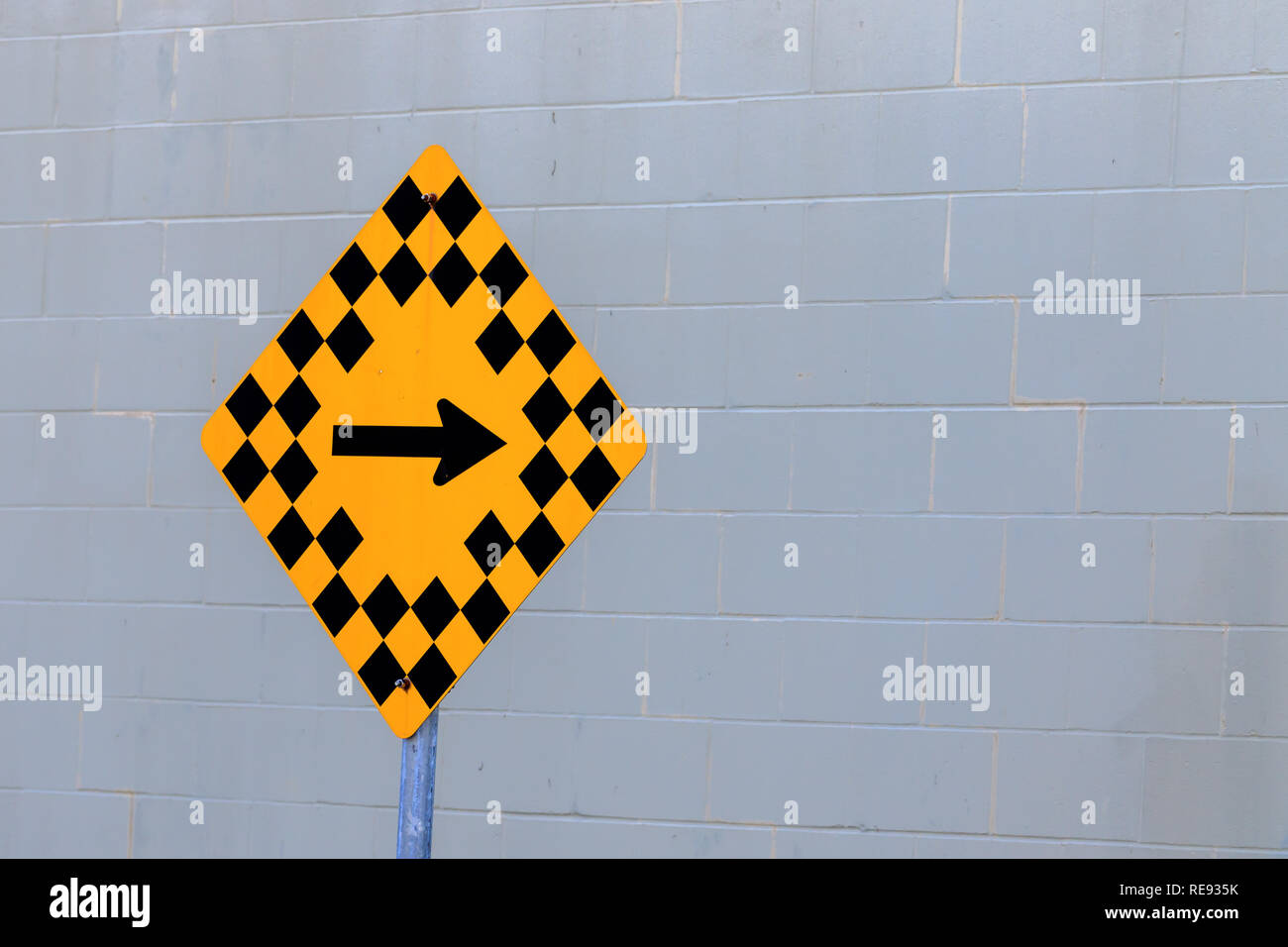 Yellow sign with small back squares and right pointing black direction ...