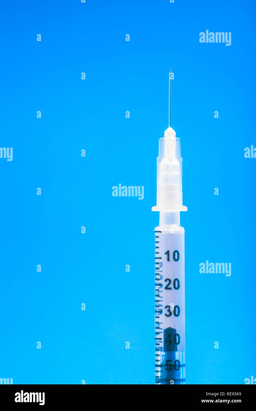 Insulin syringe closeup on blue background. Vertical photo. The concept ...