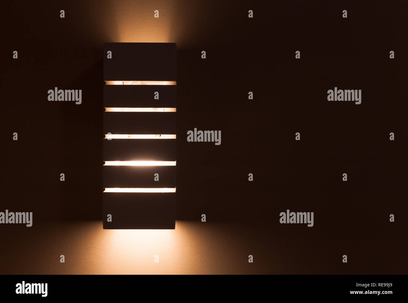 Modern wall light with line gaps glowing in dark, photo with copy space ...