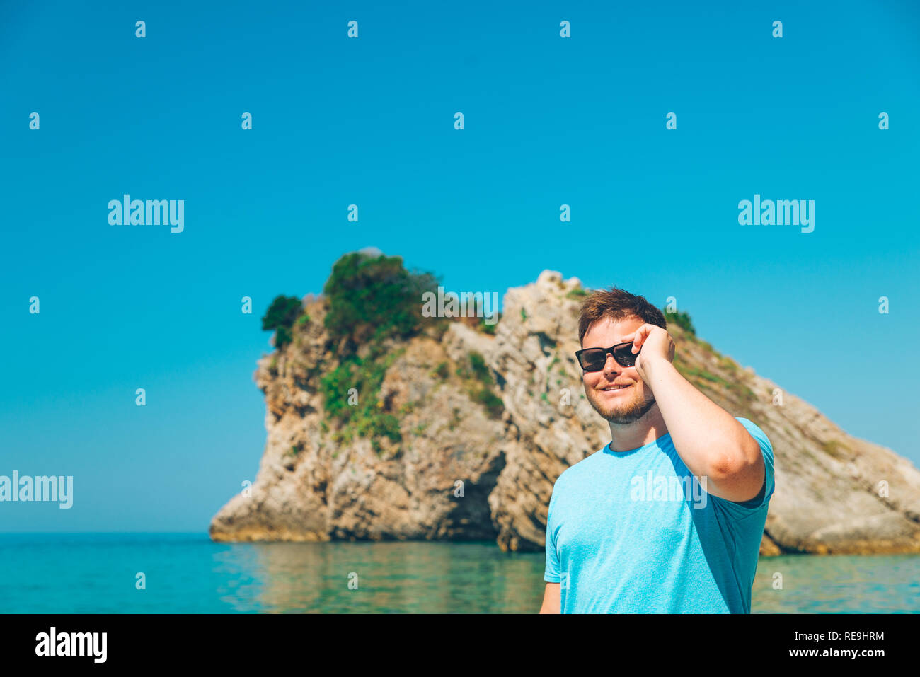 standing man with blue clear sea water on background. summer vacation ...