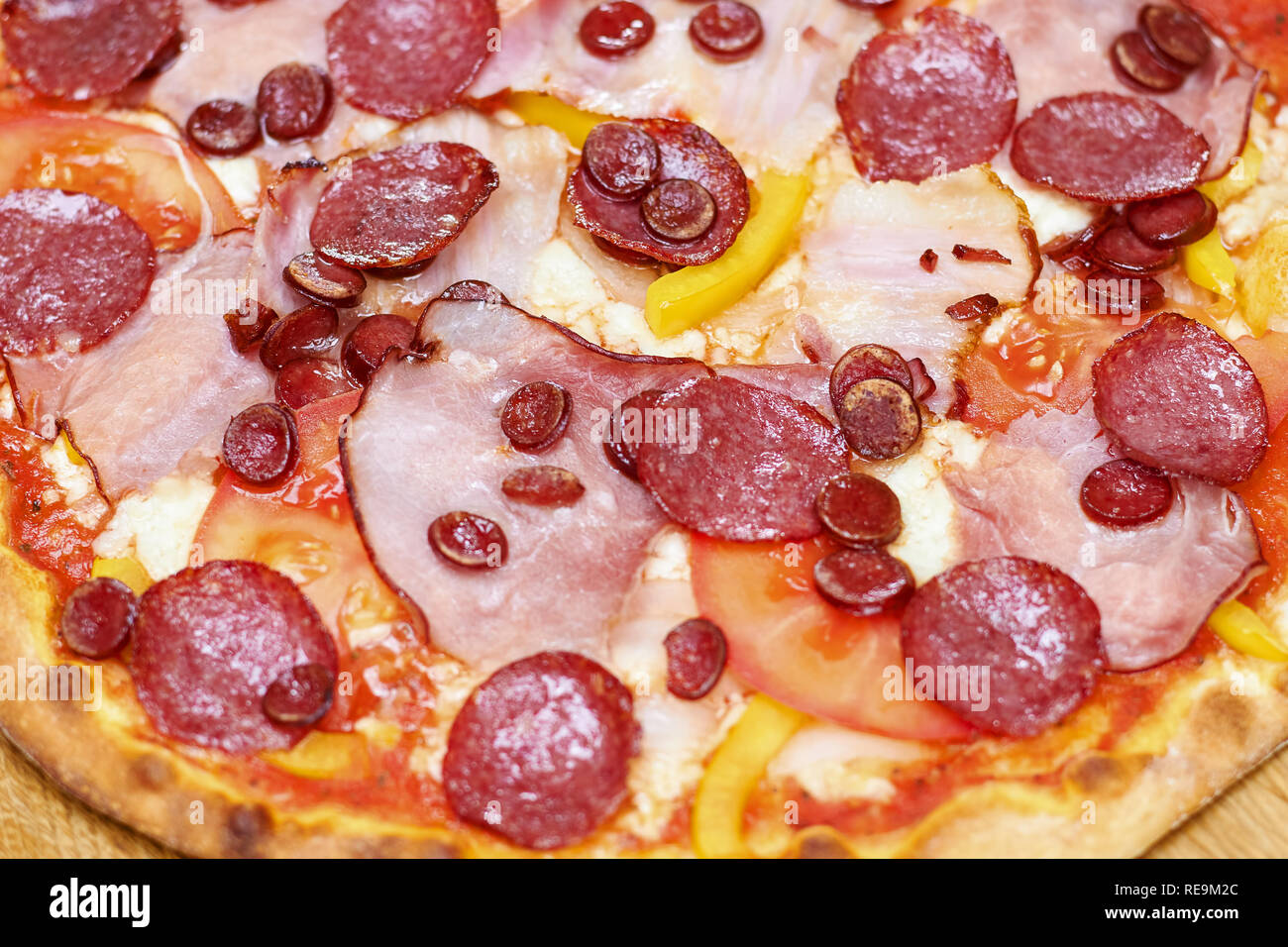 Cooked crusty salami pizza background. Closeup hot pizza with different ...