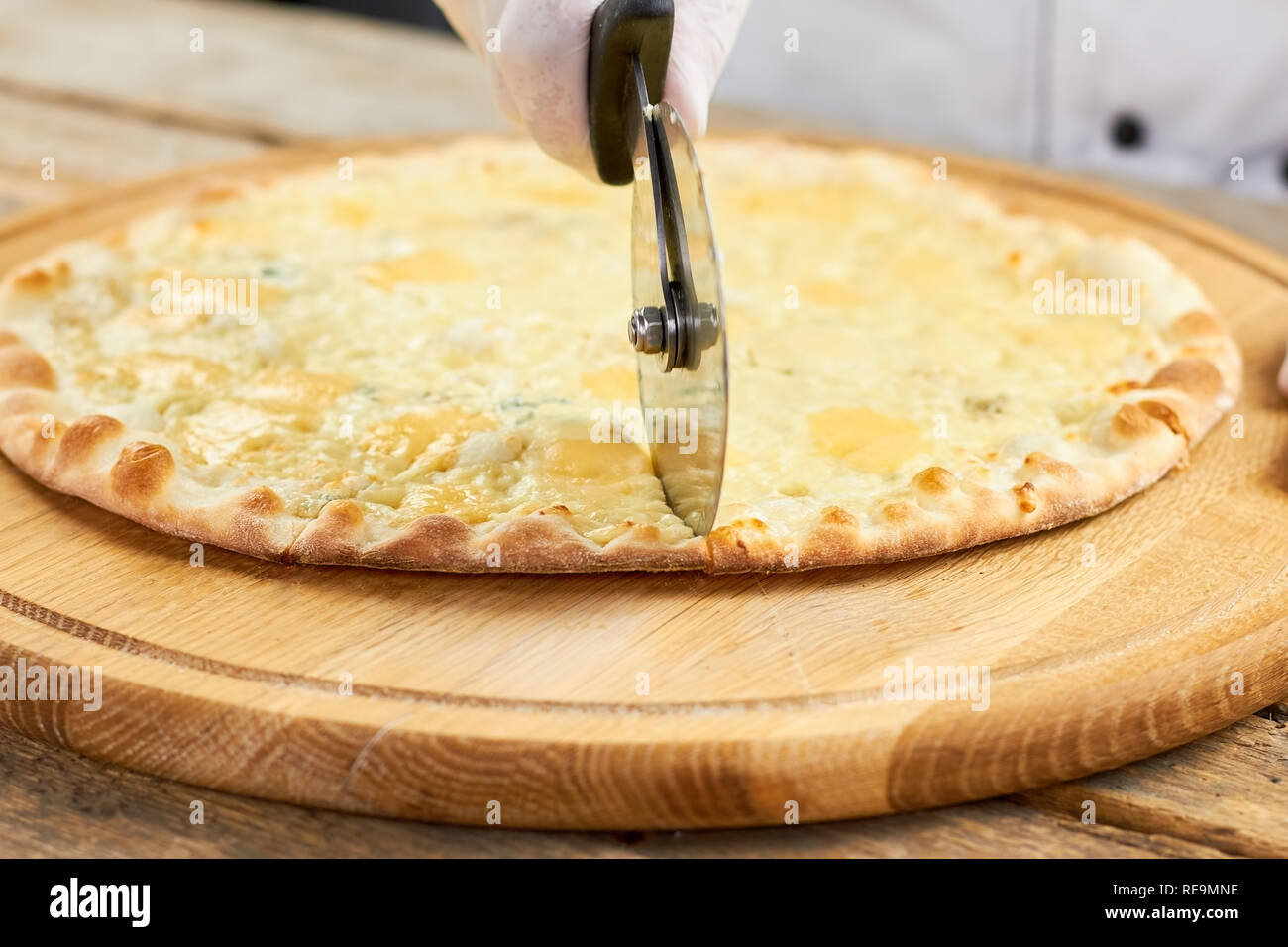 Close up wheel cutter front side view. Wheel cutter cutting pizza into ...