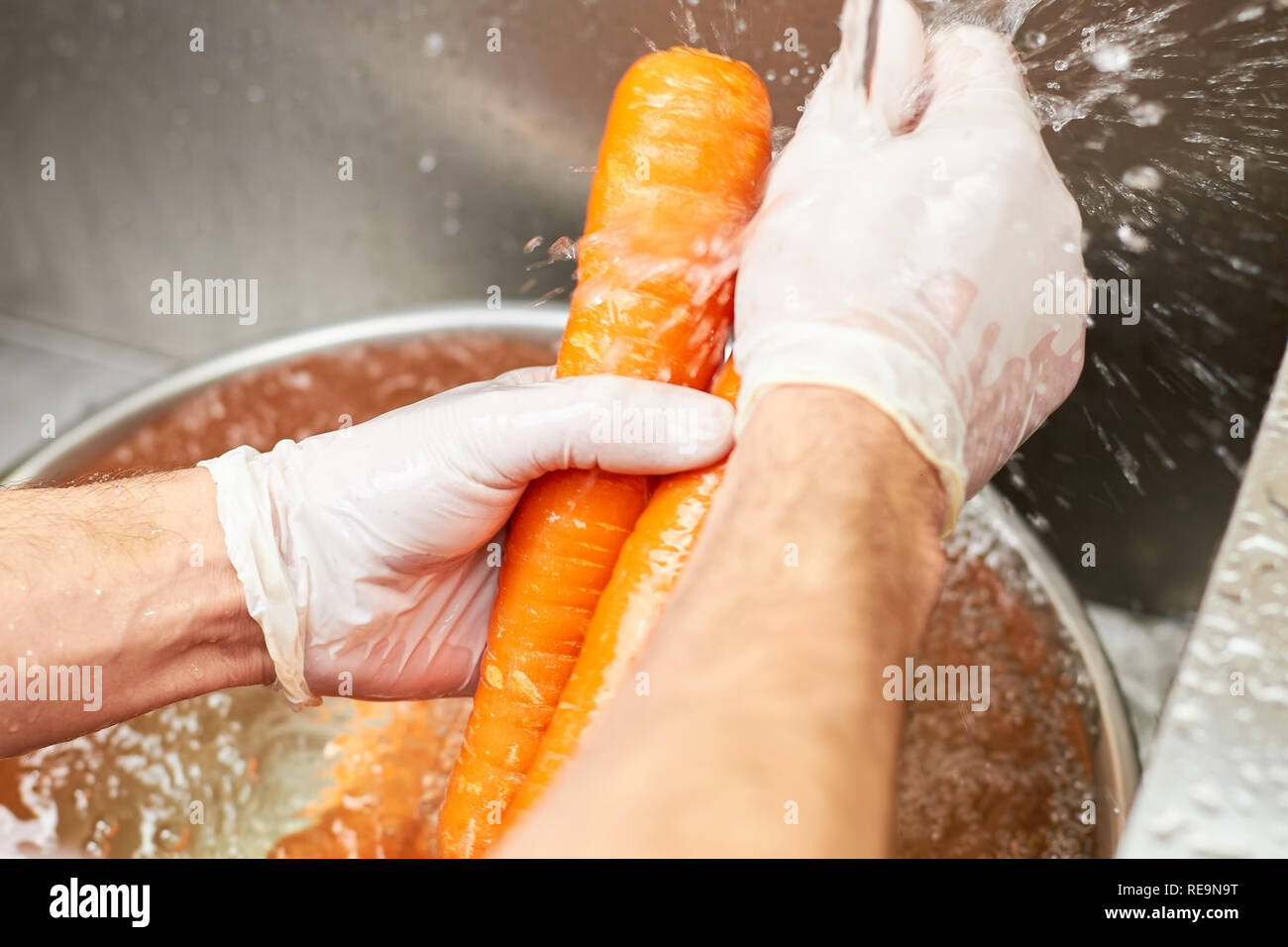 Tap water splashing, carrots washing close up. Process of washing clean ...