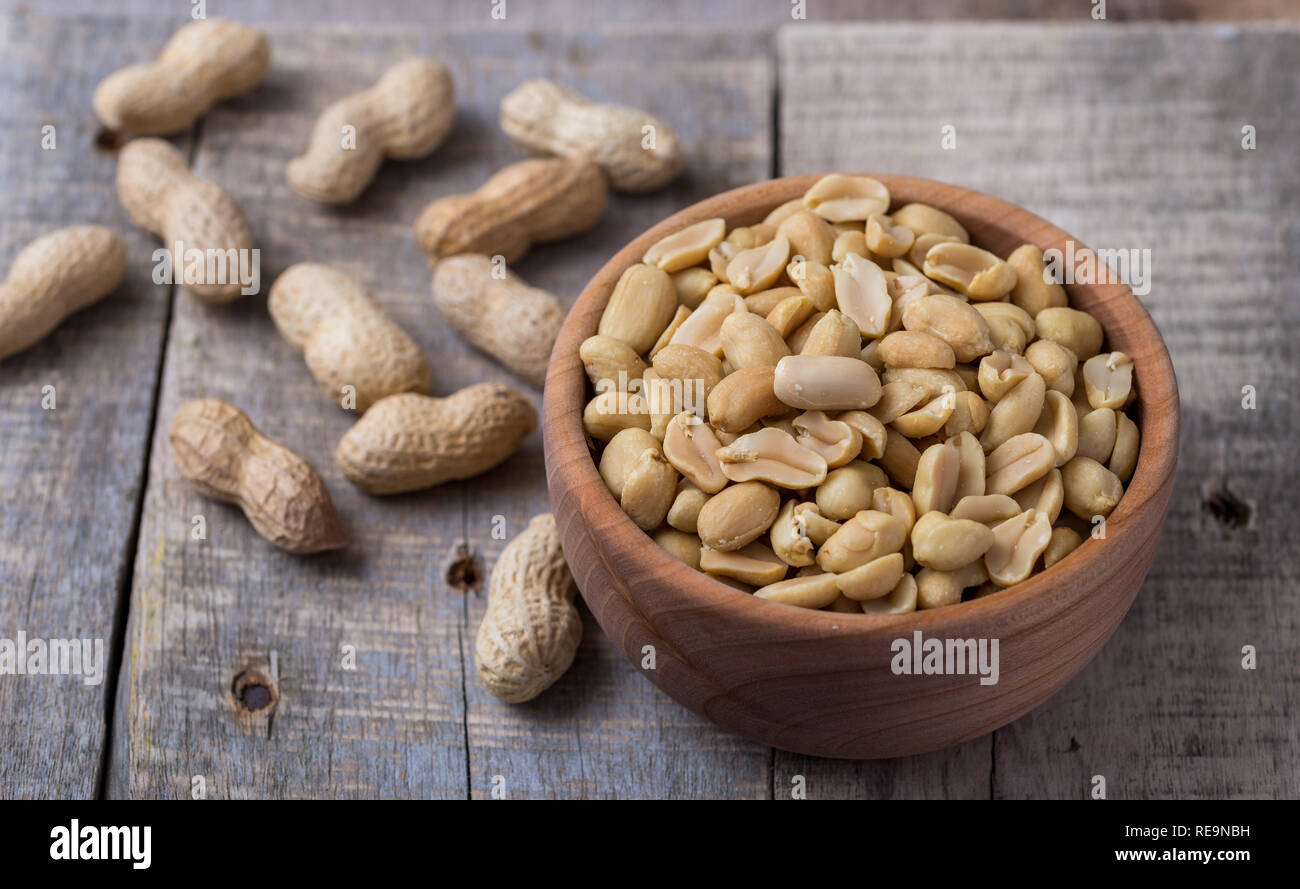 Peanuts in small wooden bowl on natural rustic desk Stock Photo - Alamy