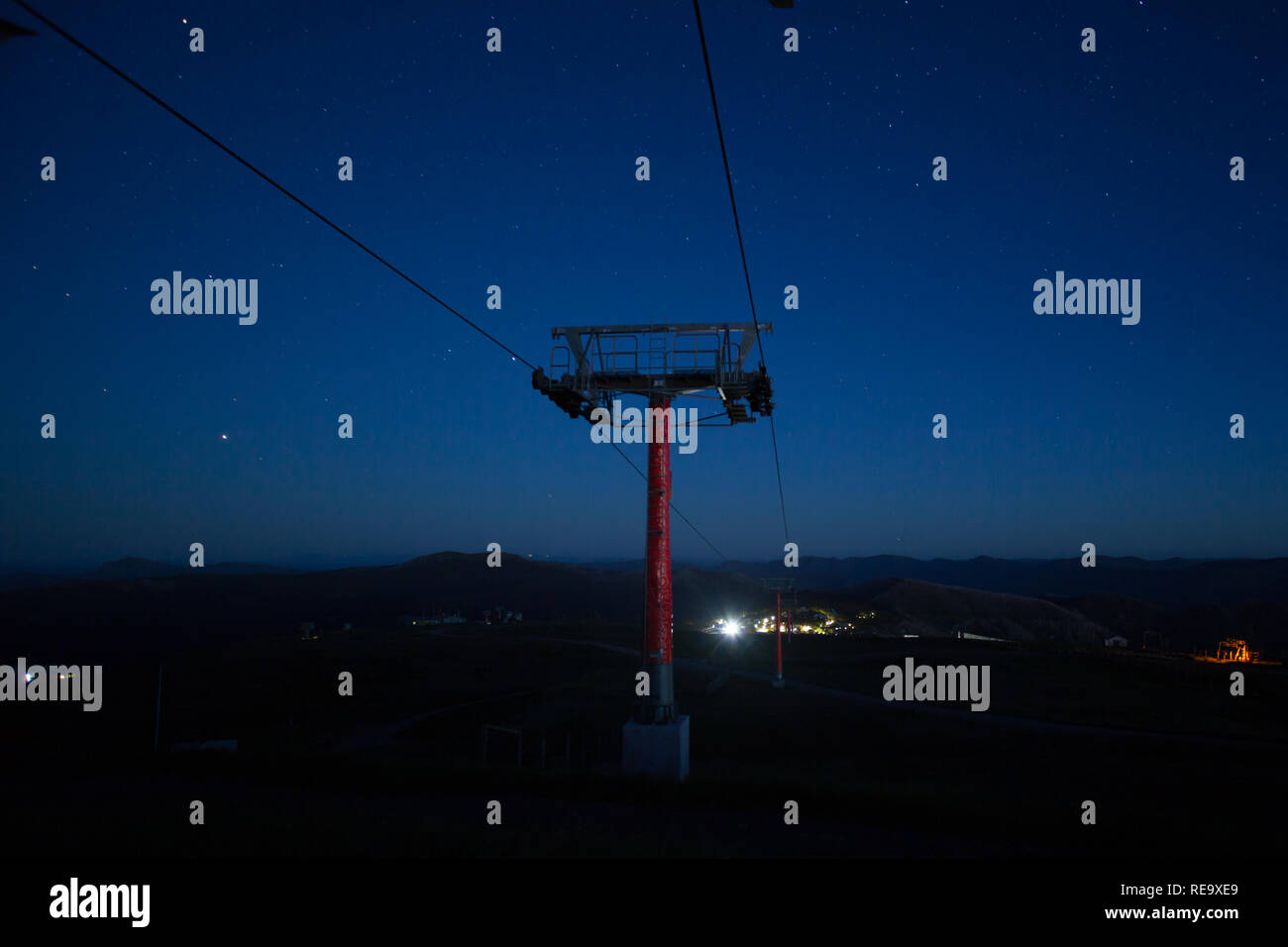 A ski lift and building under a summer starry sky at Mt Buller in the ...