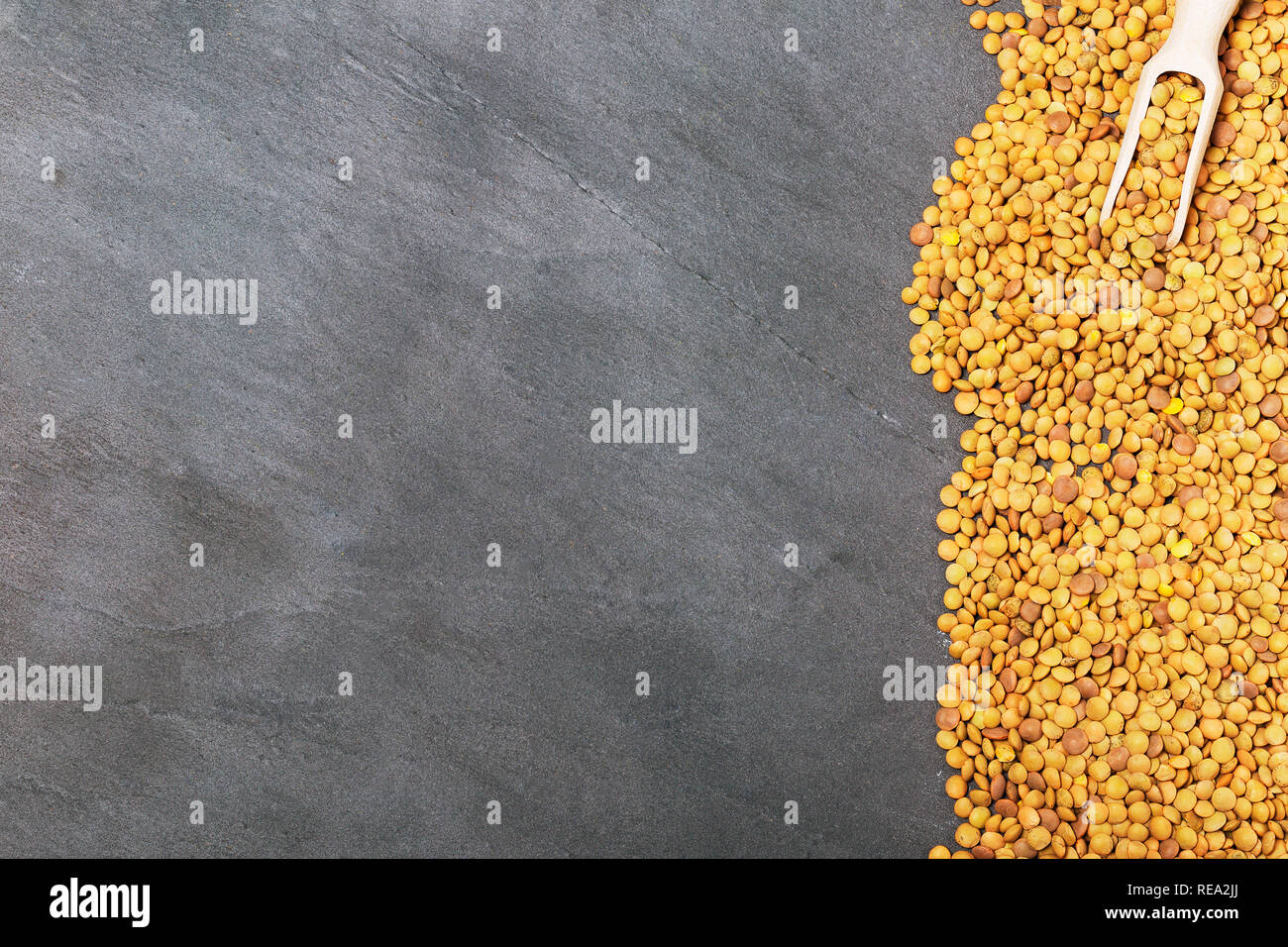 Raw lentils on balck stone background. Healthy vegetarian food concept ...