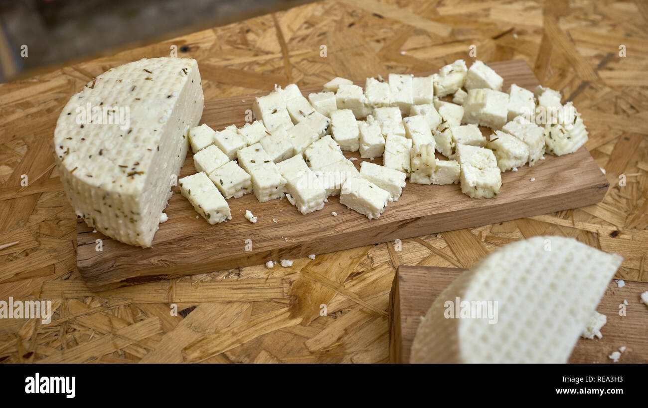fresh raw aged delicatessen cheese with fennel on board for cutting of ...