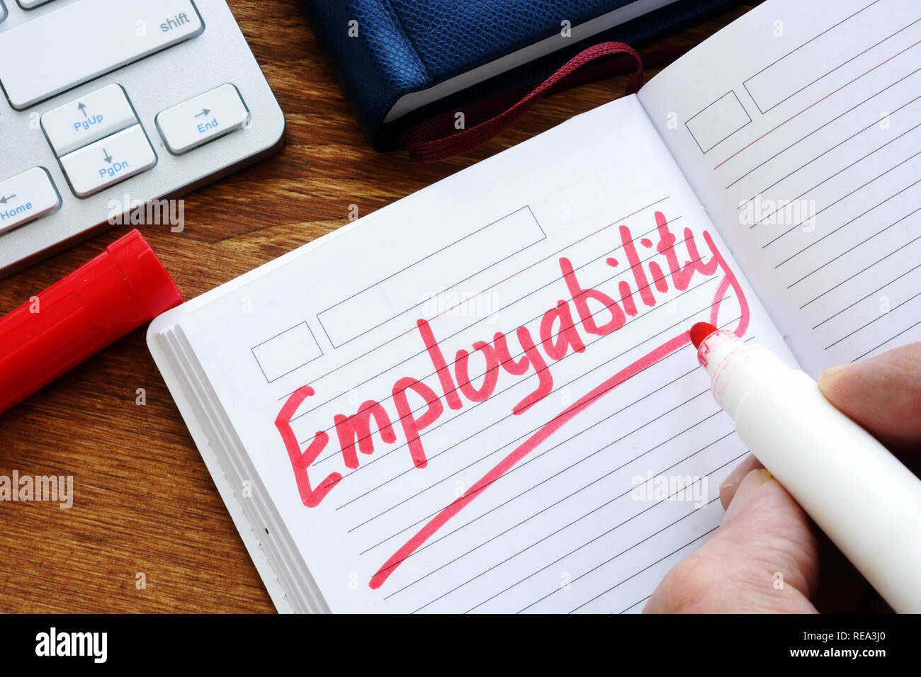 Man is writing word employability in a note Stock Photo - Alamy