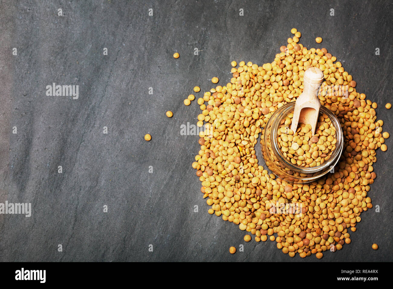 Raw lentils on balck stone background. Healthy vegetarian food concept ...