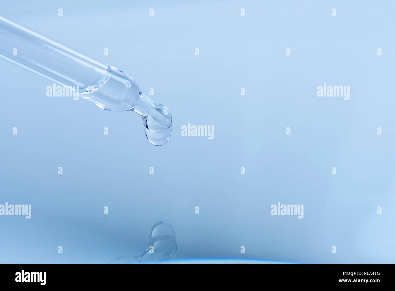 one drop water out of a pipette against blue background Stock Photo - Alamy