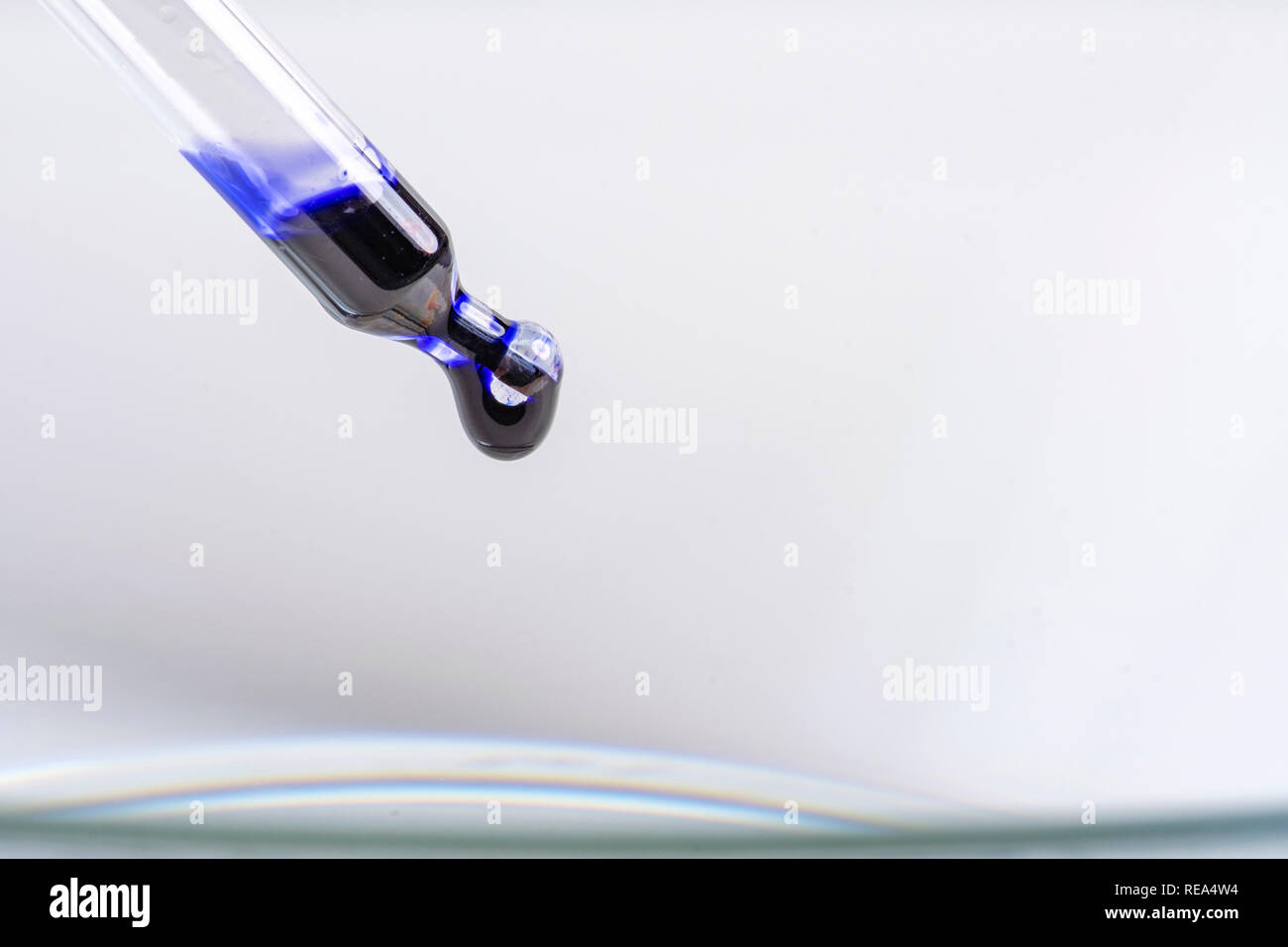 blue liquid from a pipette with a droplet Stock Photo - Alamy
