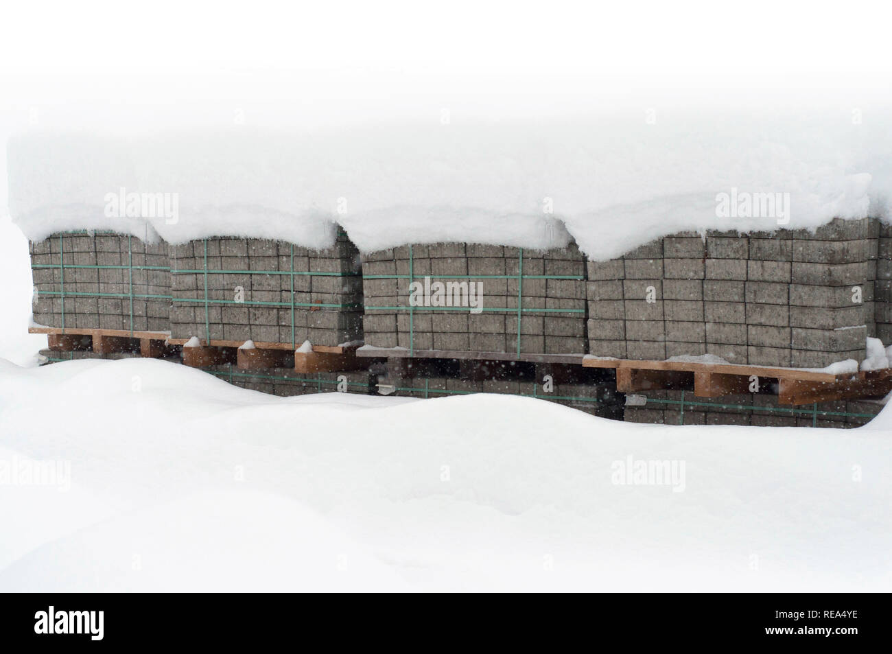 A view of bricks under snow. Snow cover stack of brick. Construction ...