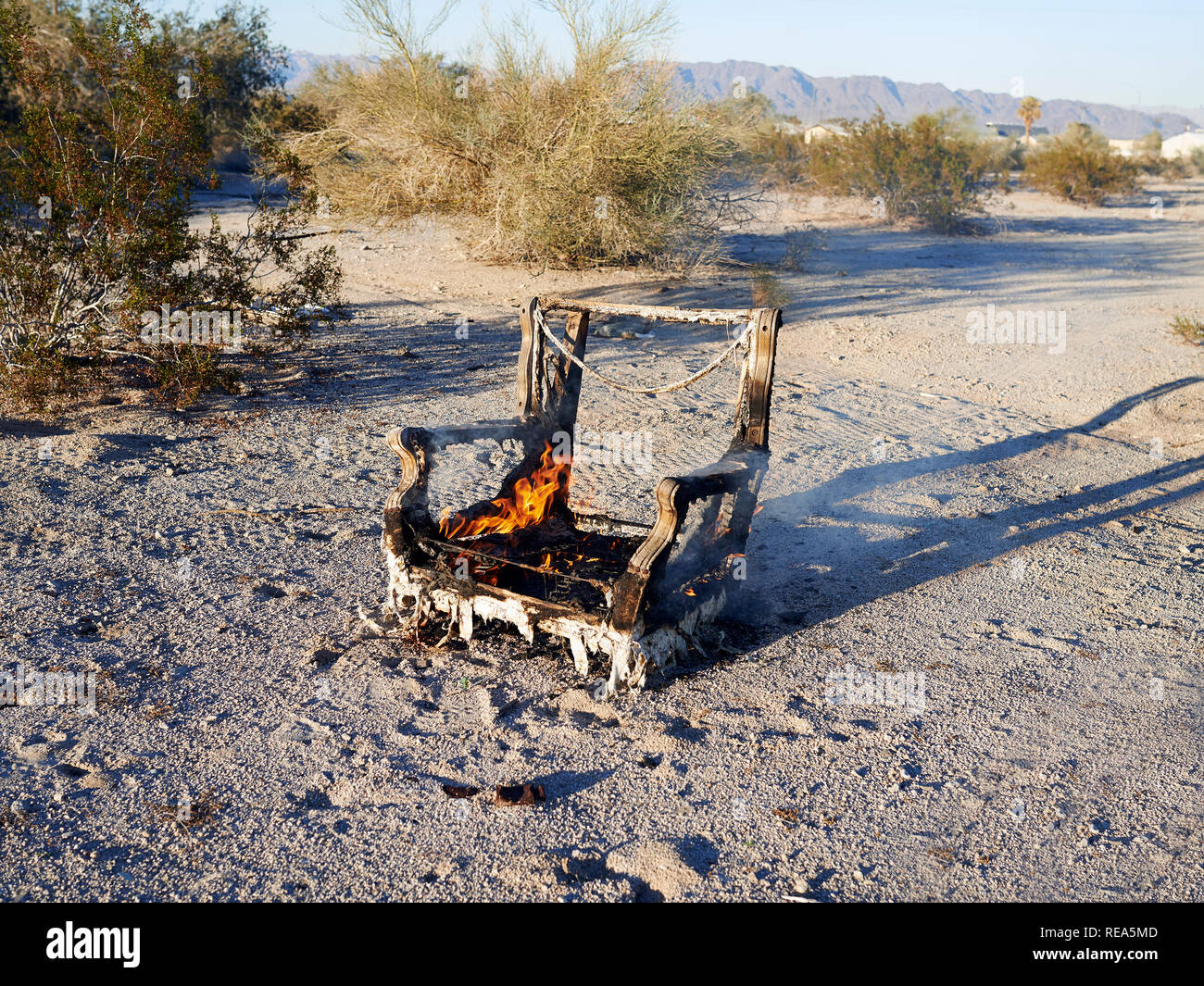 Chair on fire in the desert Stock Photo - Alamy