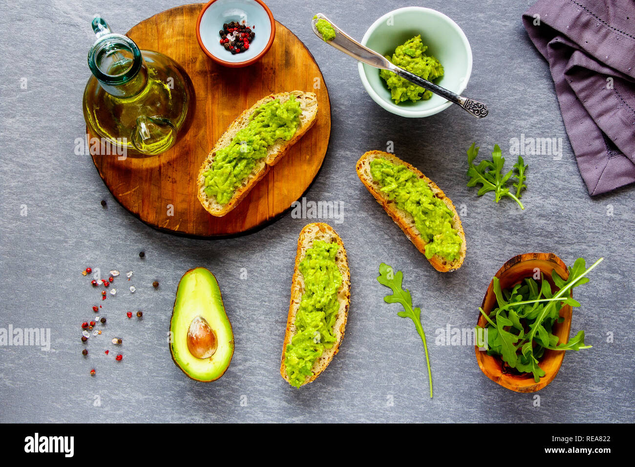 Flat lay of avocado toasts with arugula. Good fats raw healthy eating ...