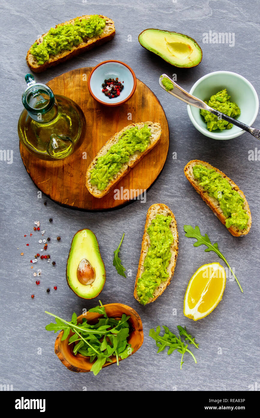 Flat lay of avocado toasts and ingredients. Good fats raw healthy ...