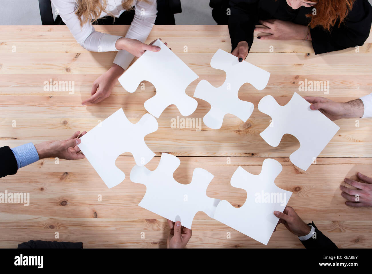 Business people work together to build a puzzle. Concept of teamwork ...