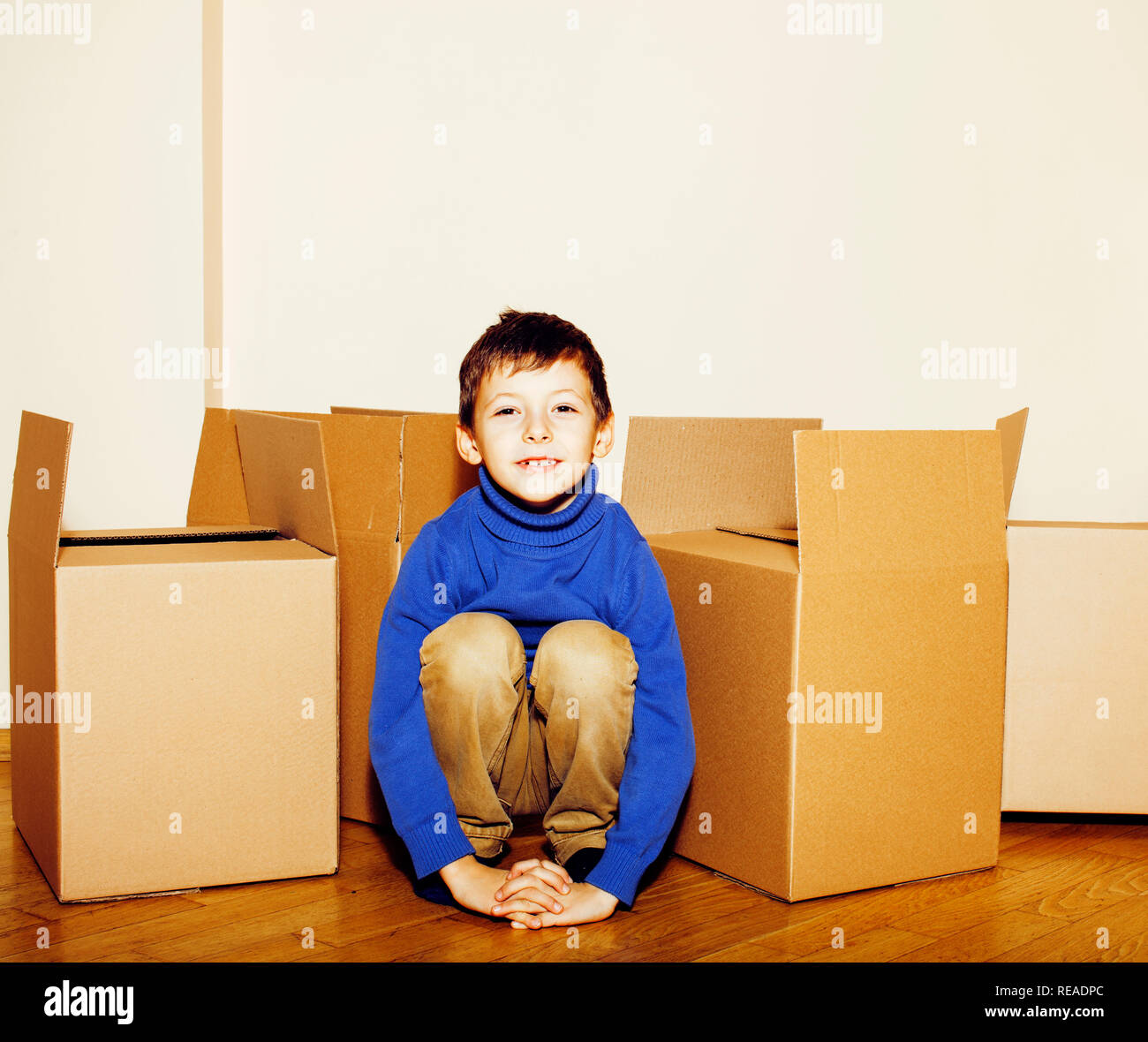 little cute boy in empty room with many boxes, remoove to new home ...