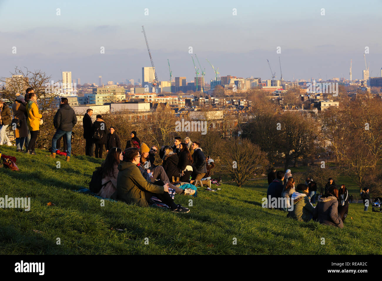 People are seen relaxing at the Primrose Hill to see the golden winter ...