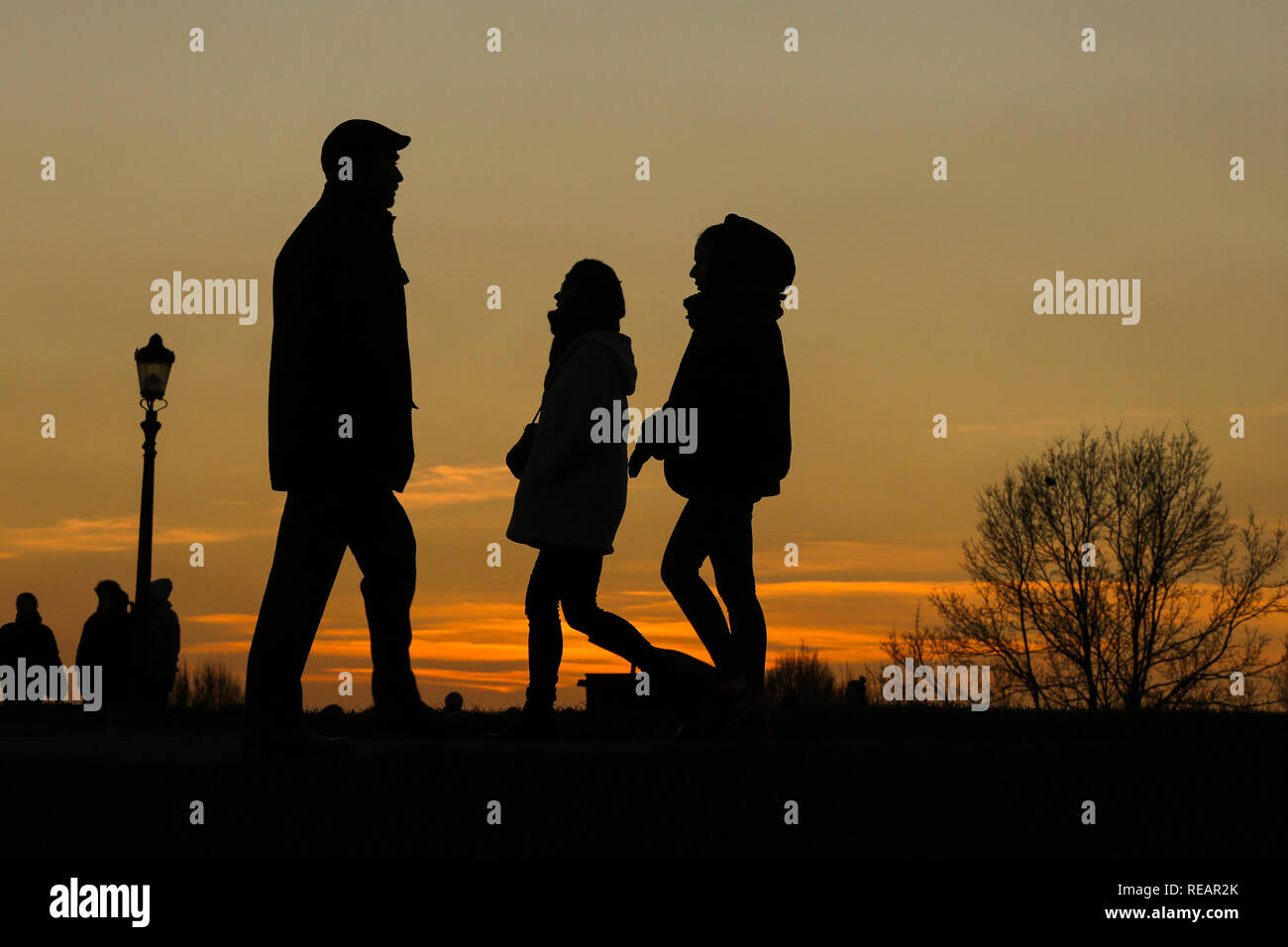 People are seen at the Primrose Hill during a golden winter sunset ...