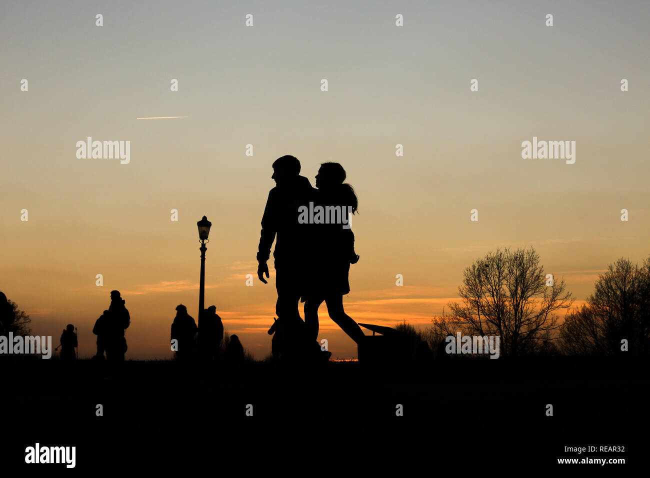People are seen at the Primrose Hill during a golden winter sunset ...