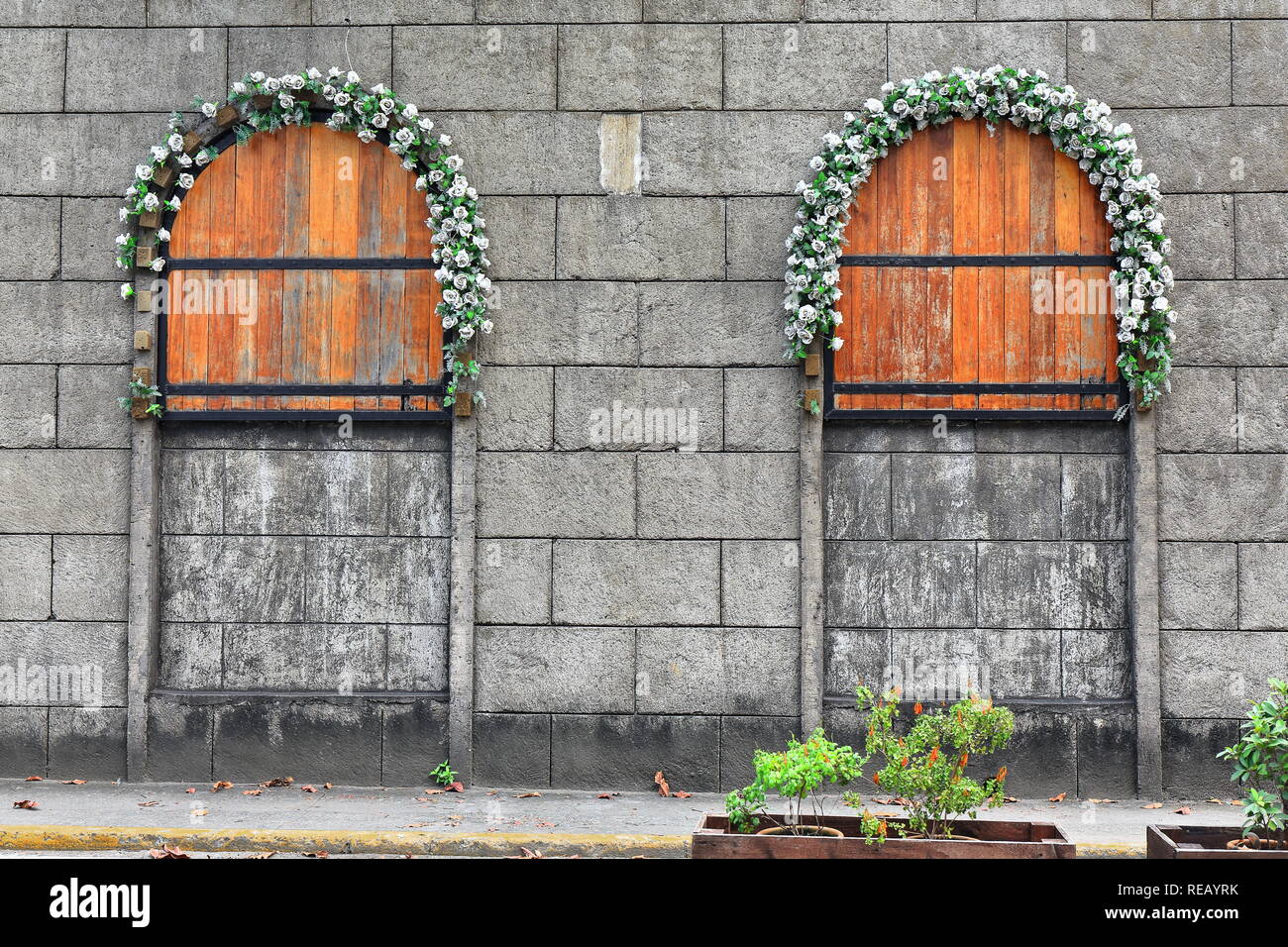 Arched boarded up windows with wooden shutters-white roses garlands ...