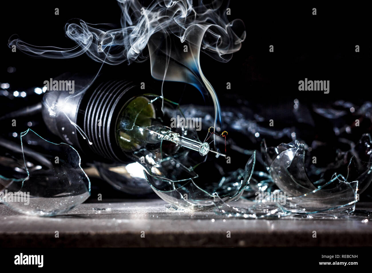 amazing explosion of a burning light bulb with splinters and smoke on a ...