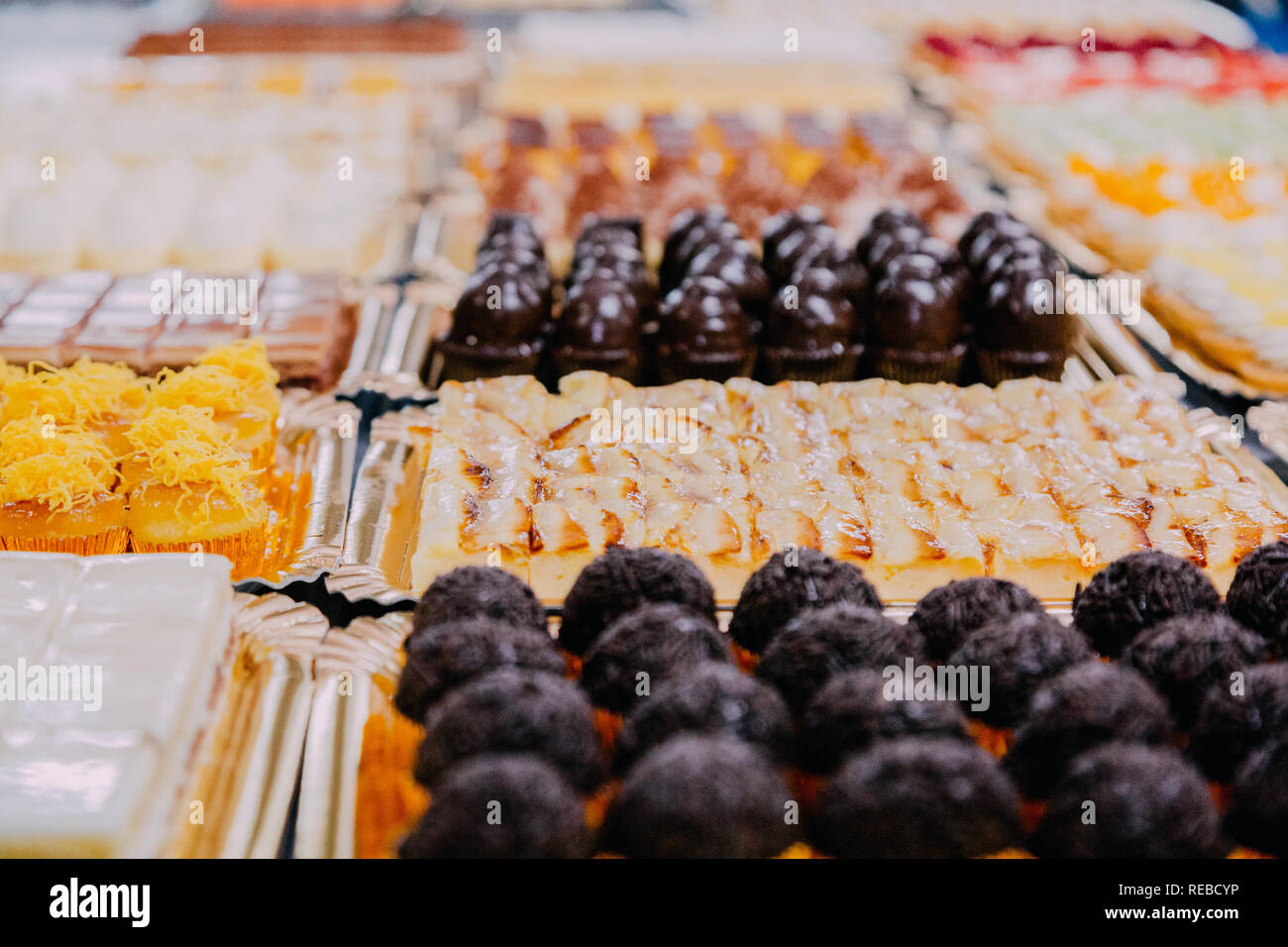 many different sweets prepared on the metal table of a food factory ...