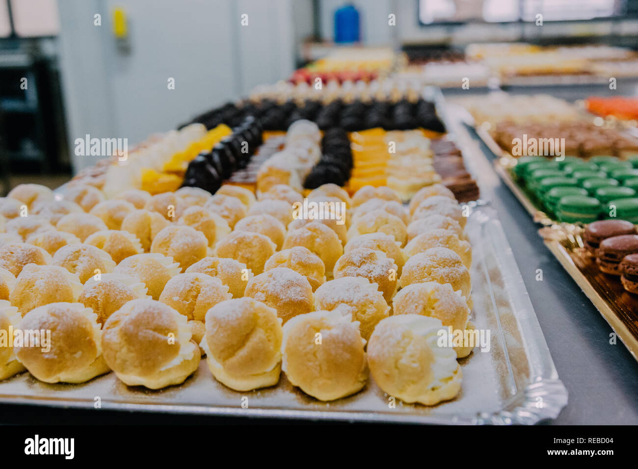 many different sweets prepared on the metal table of a food factory ...