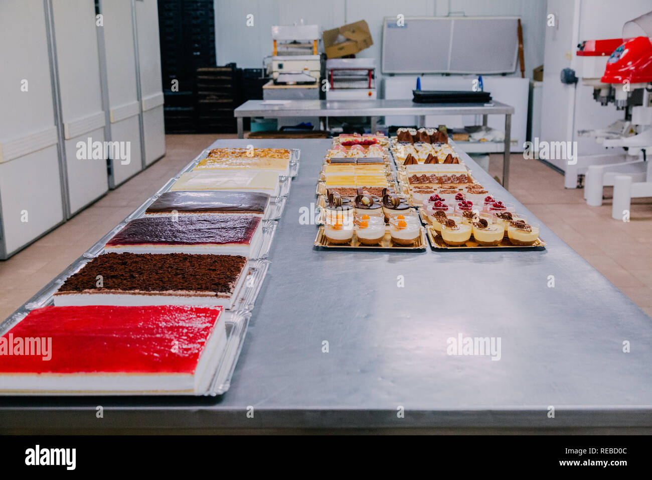 many different sweets prepared on the metal table of a food factory ...