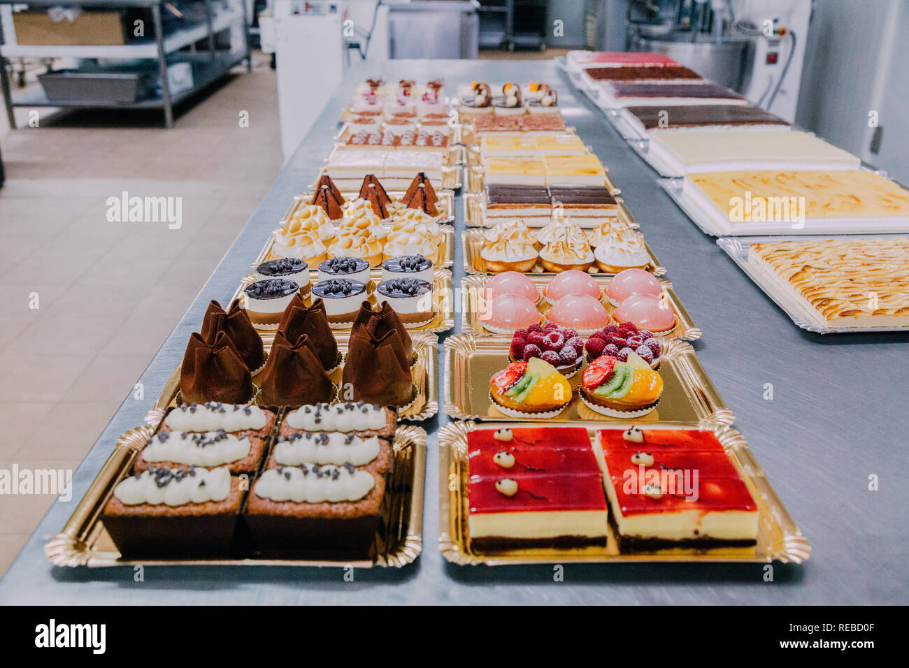many different sweets prepared on the metal table of a food factory ...