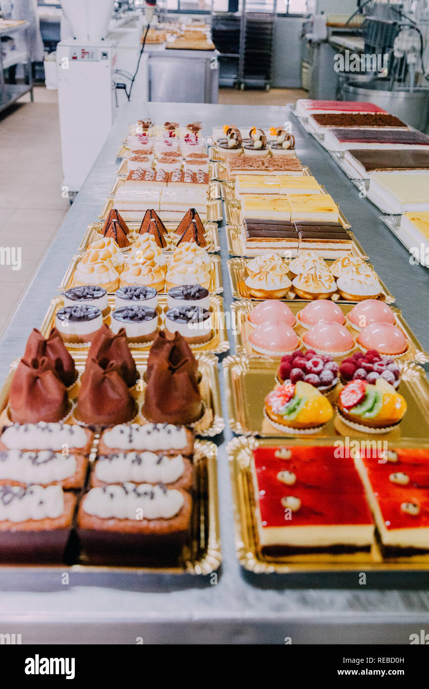 many different sweets prepared on the metal table of a food factory ...