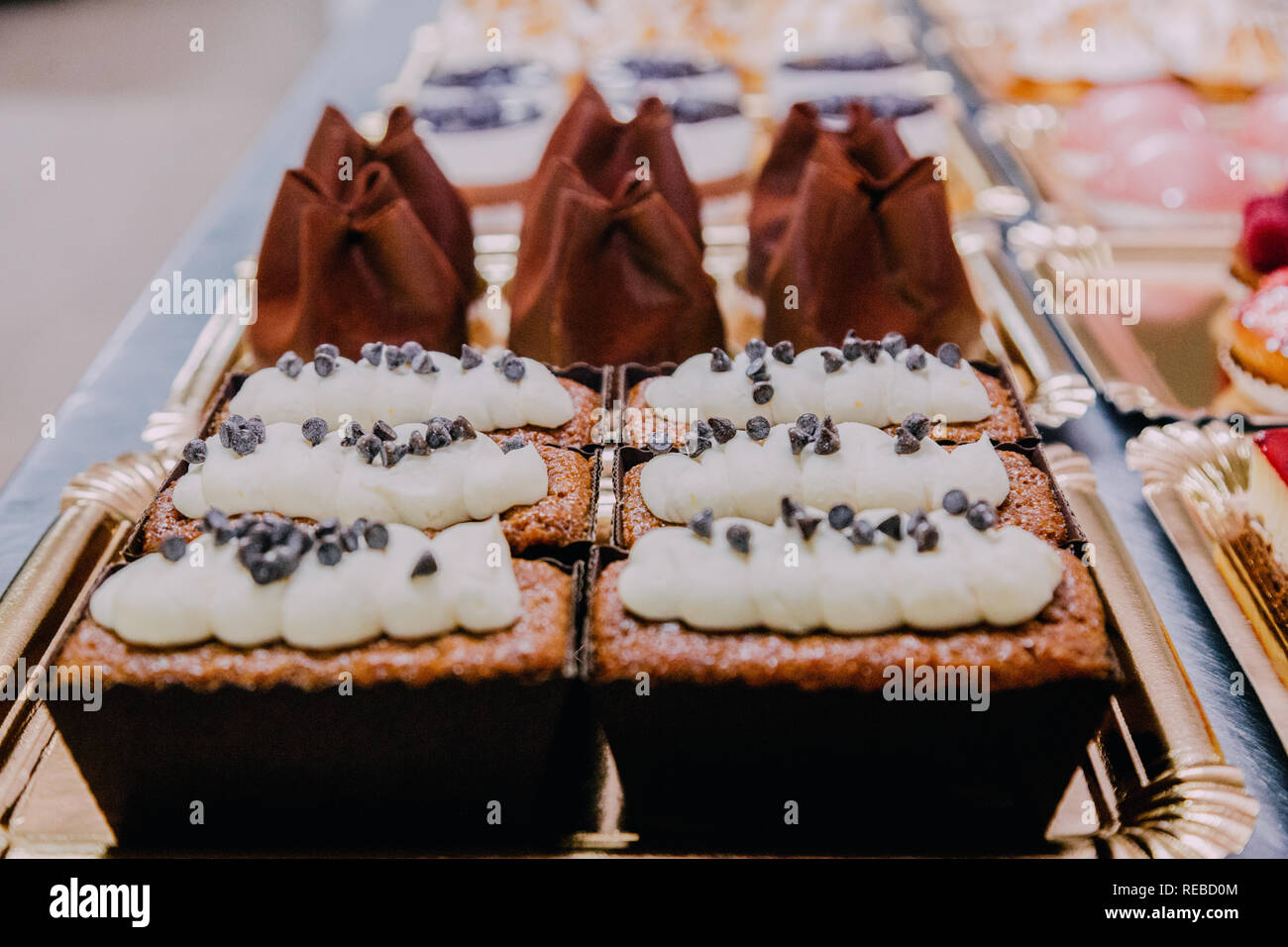 many different sweets prepared on the metal table of a food factory ...
