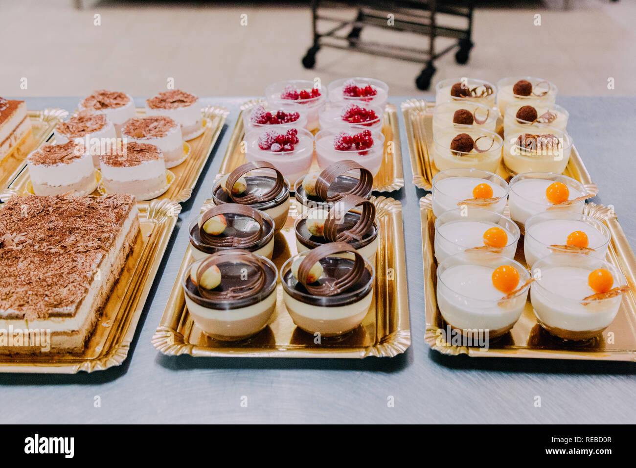 many different sweets prepared on the metal table of a food factory ...