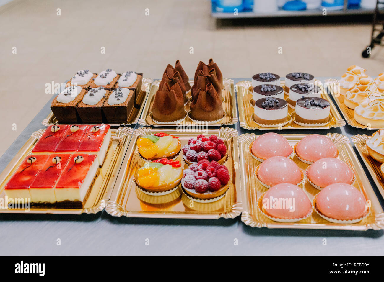 many different sweets prepared on the metal table of a food factory ...