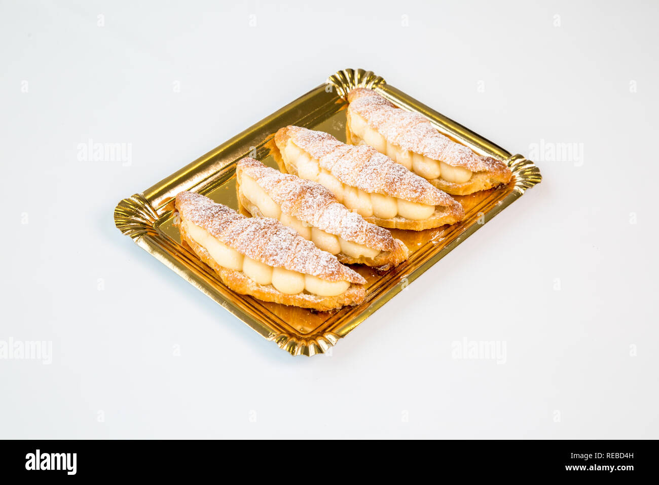 sweet pastries in a gold tray on white background Stock Photo - Alamy
