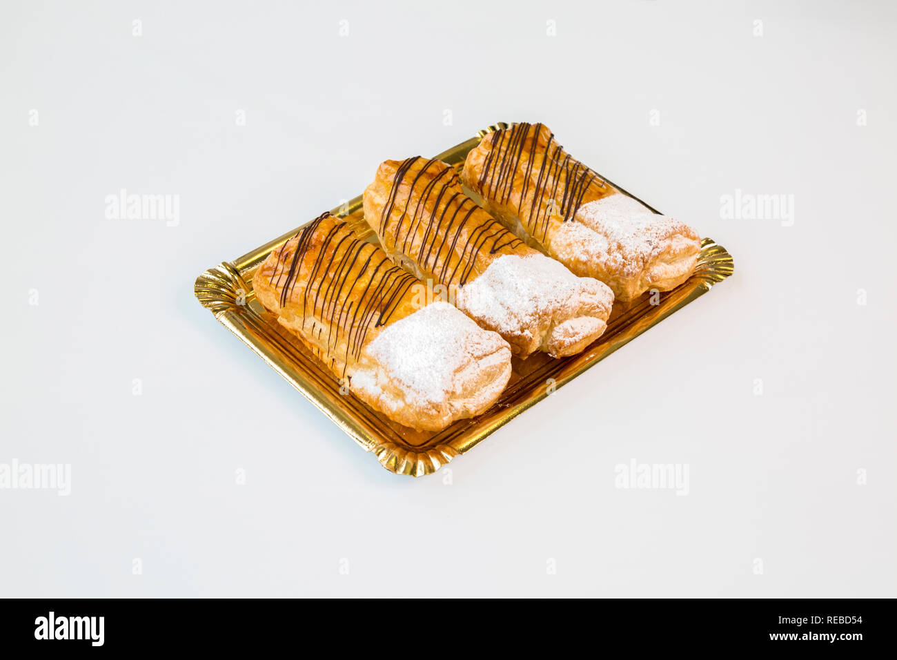 sweet pastries in a gold tray on white background Stock Photo - Alamy