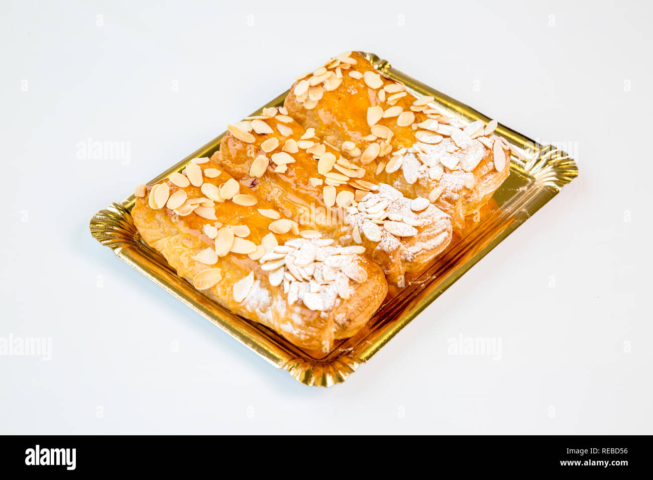 sweet pastries in a gold tray on white background Stock Photo - Alamy