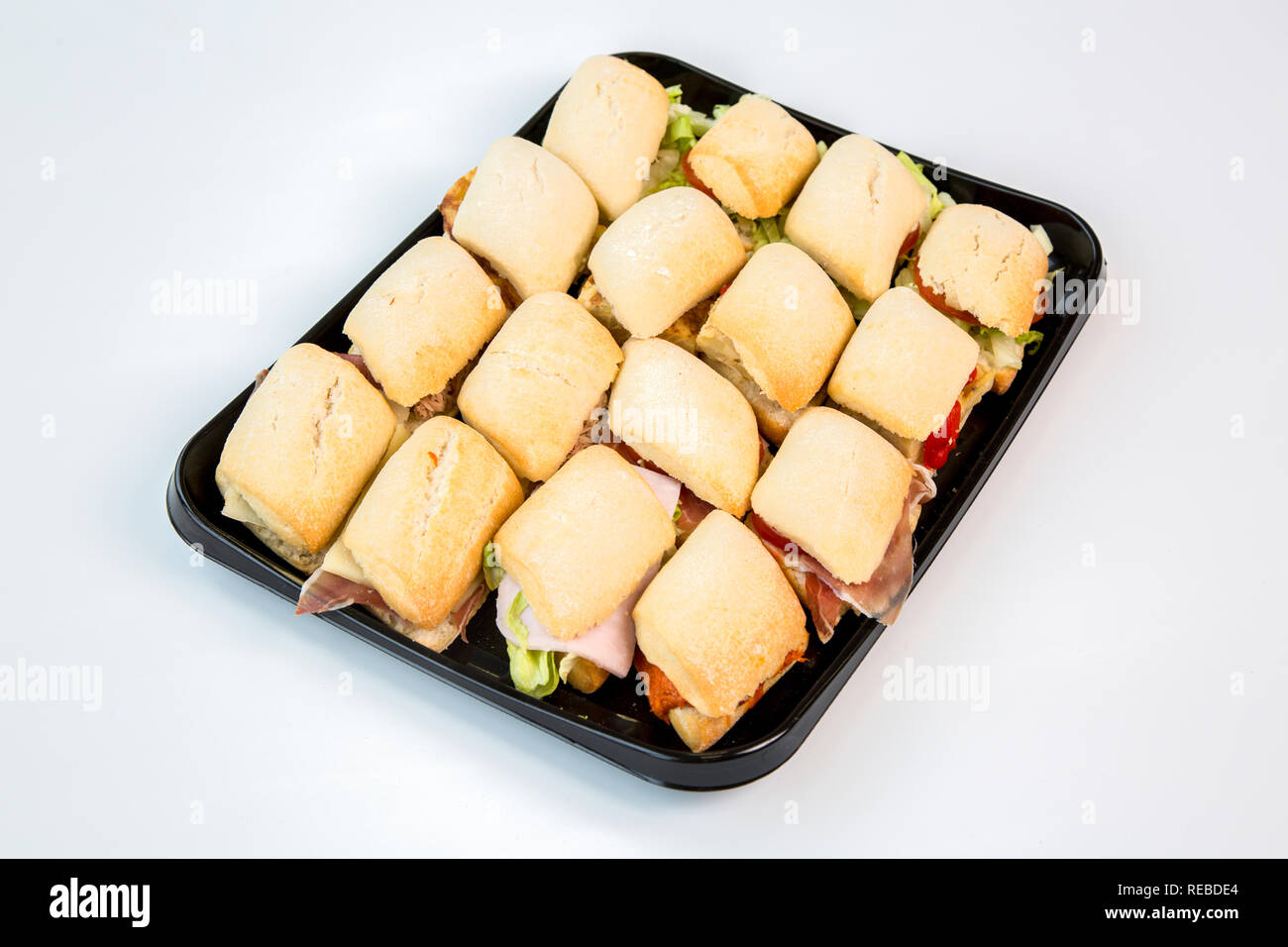 small sandwiches on a black tray prepared to takeaway on white ...
