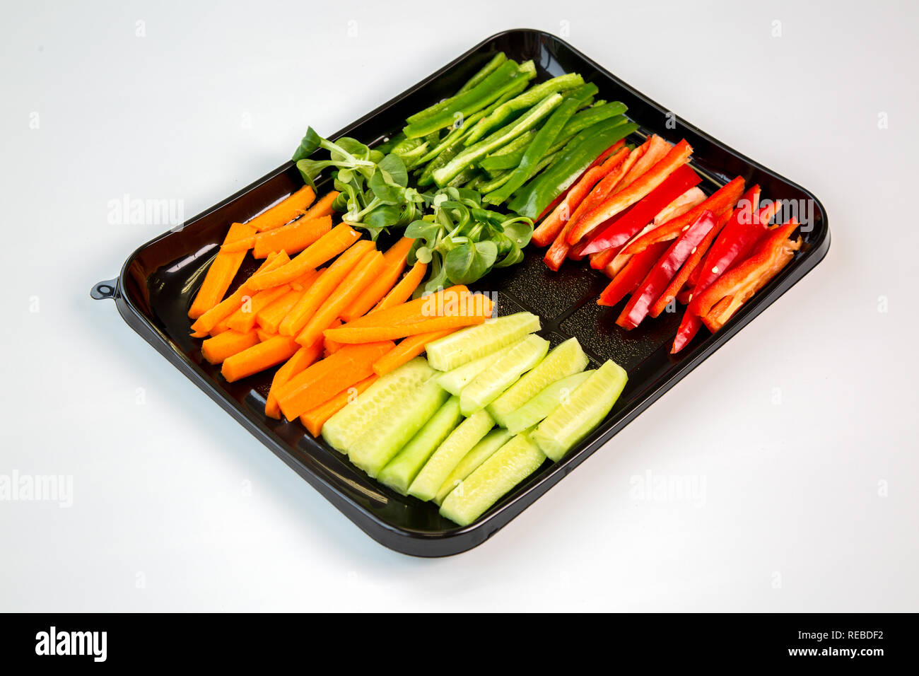 raw vegetables cut into strips on a black tray prepared to takeaway on ...