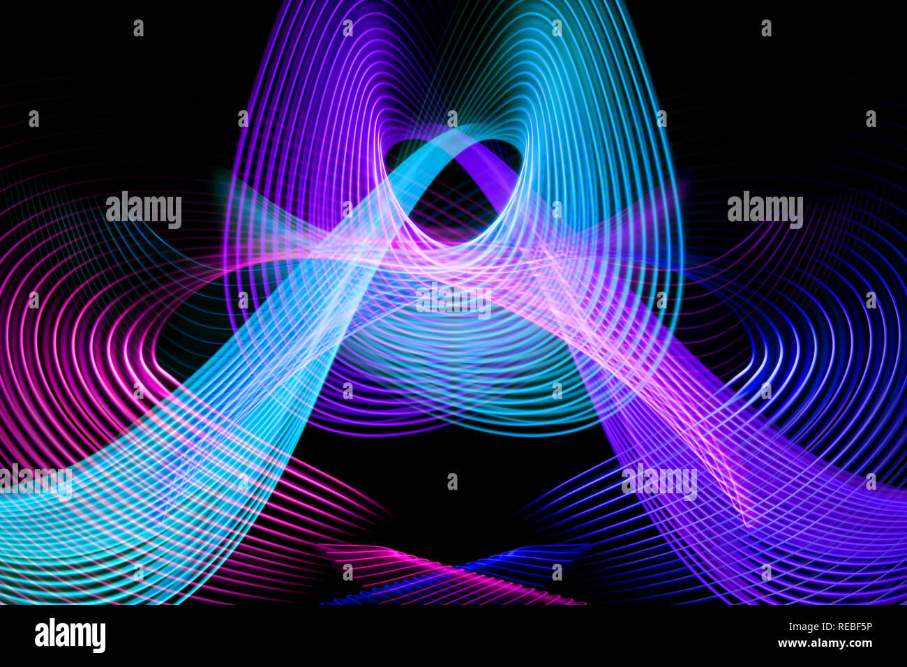 Abstract rainbow neon glowing crossing lines pattern. Dark background of colorful neon blue ...
