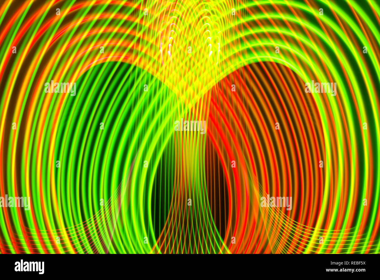 Abstract rainbow neon glowing crossing lines pattern. Dark background of colorful neon yellow ...