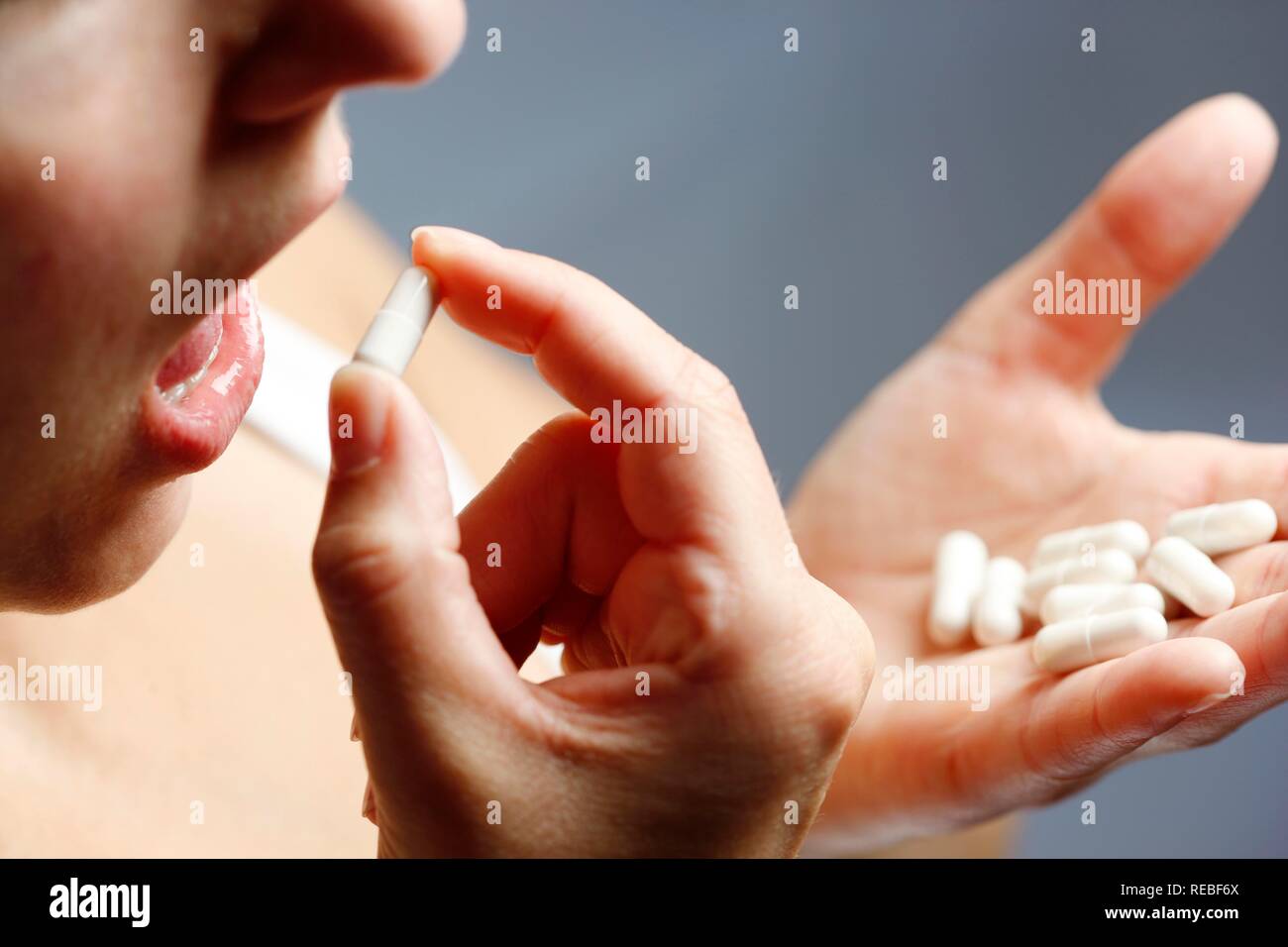 Young woman taking tablets, capsules Stock Photo - Alamy