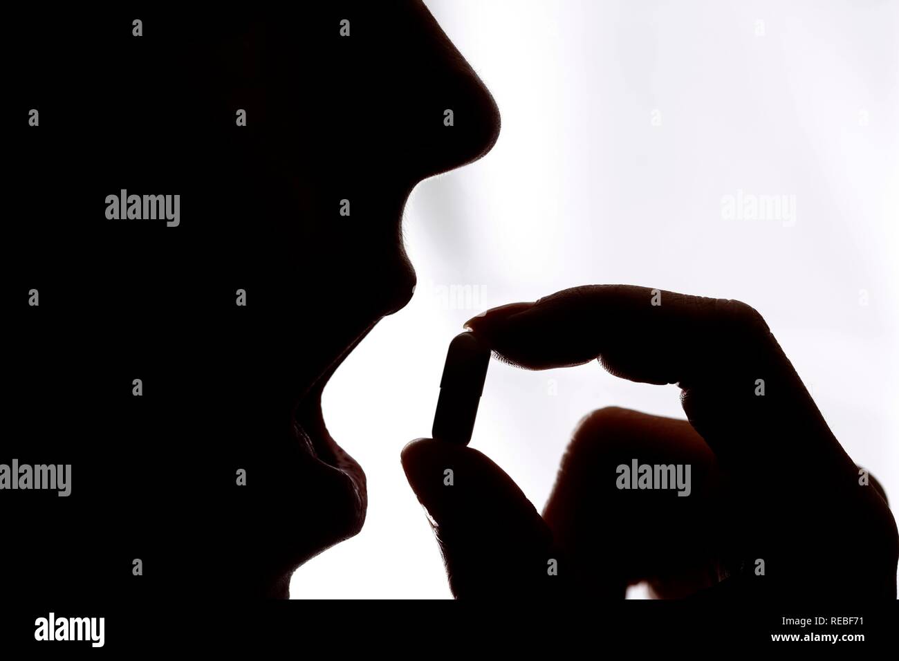 Young woman taking a tablet, capsule Stock Photo - Alamy