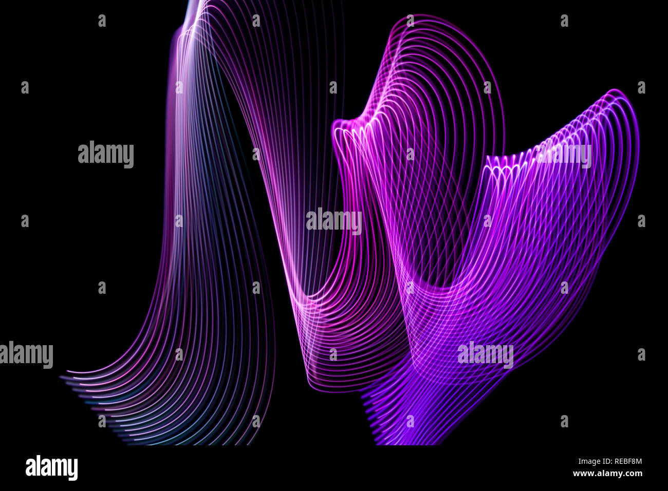 Abstract rainbow neon glowing crossing lines pattern. Dark background of colorful neon yellow ...