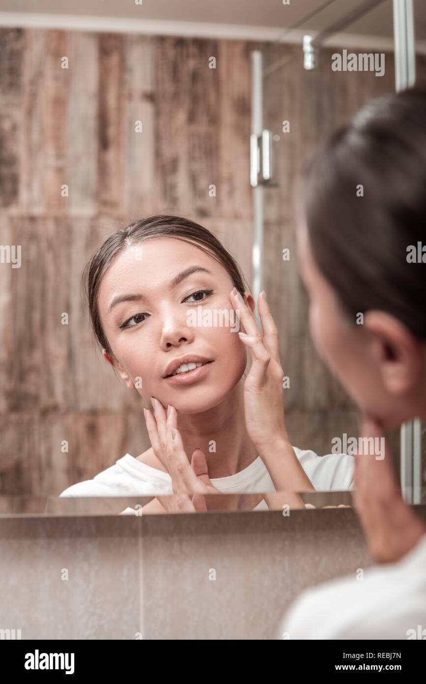 Appealing young woman taking care of skin on her face Stock Photo - Alamy