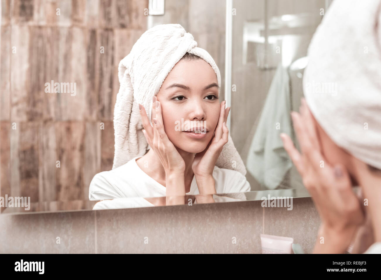 Nice young Asian woman touching her cheeks Stock Photo - Alamy