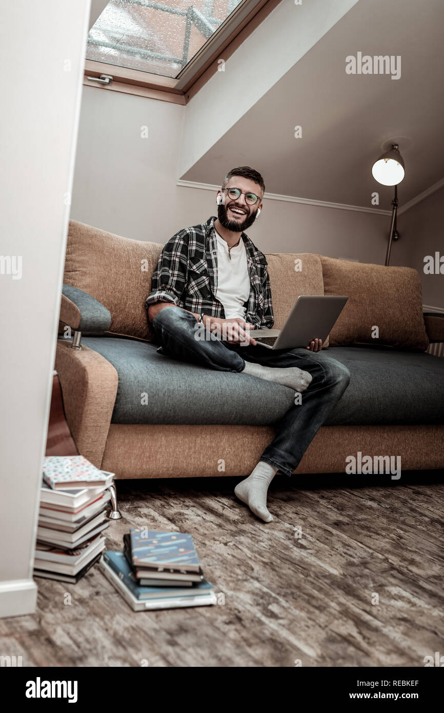 Happy nice man sitting on the sofa Stock Photo - Alamy