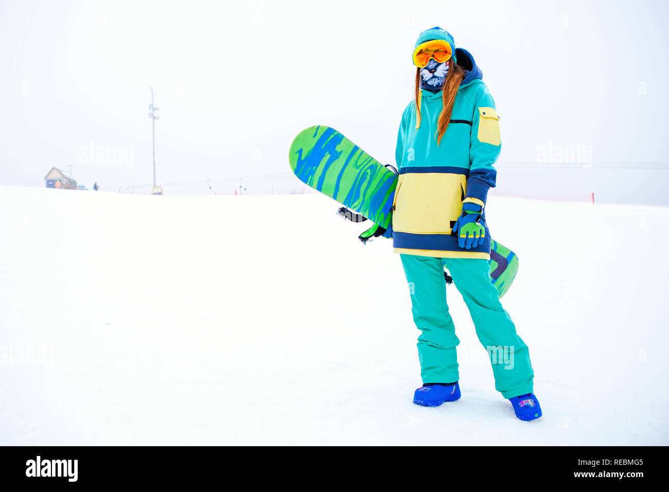 Portrait of beautiful young snowboarder girl holding snowboard Stock ...