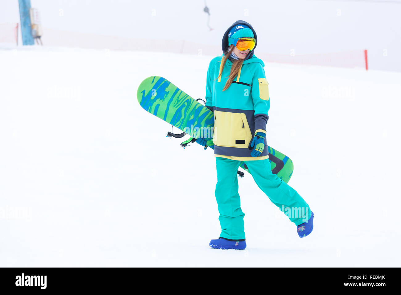 Portrait of beautiful young snowboarder girl holding snowboard Stock ...