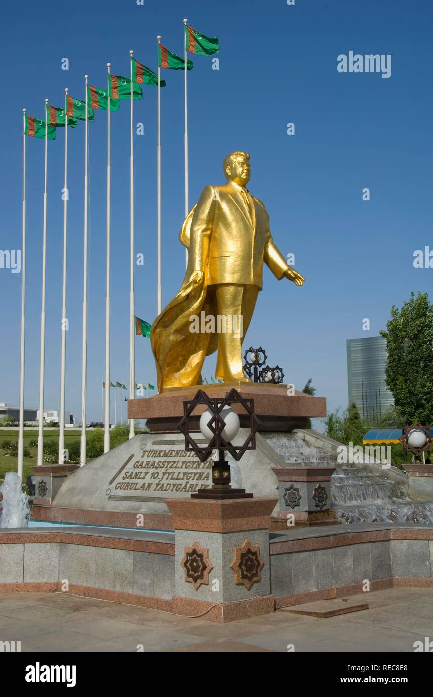 Gold covered statue of President Turkmenbasy in front of the monument ...